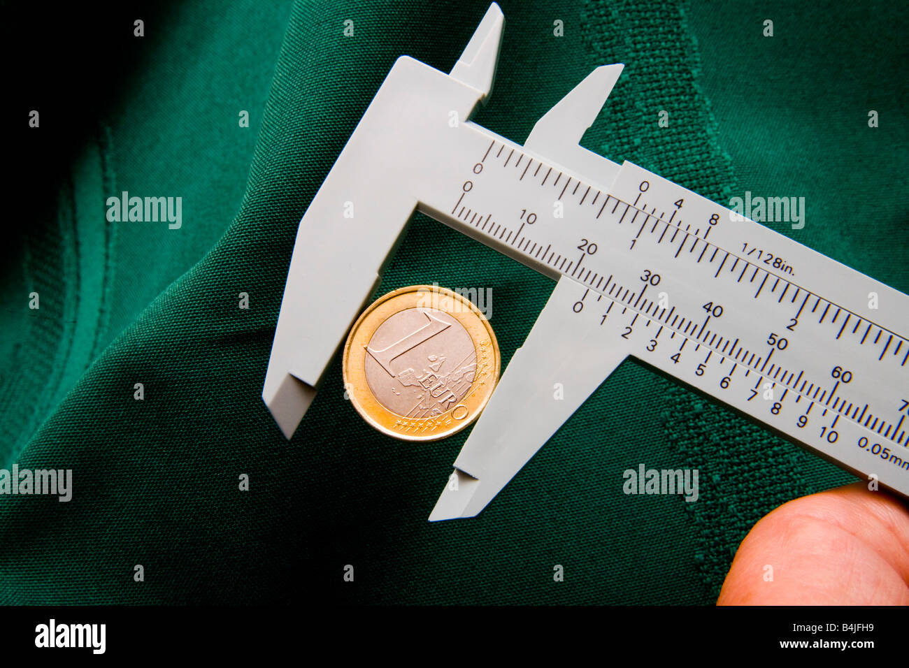 Euro coin being measured in calipers Stock Photo - Alamy