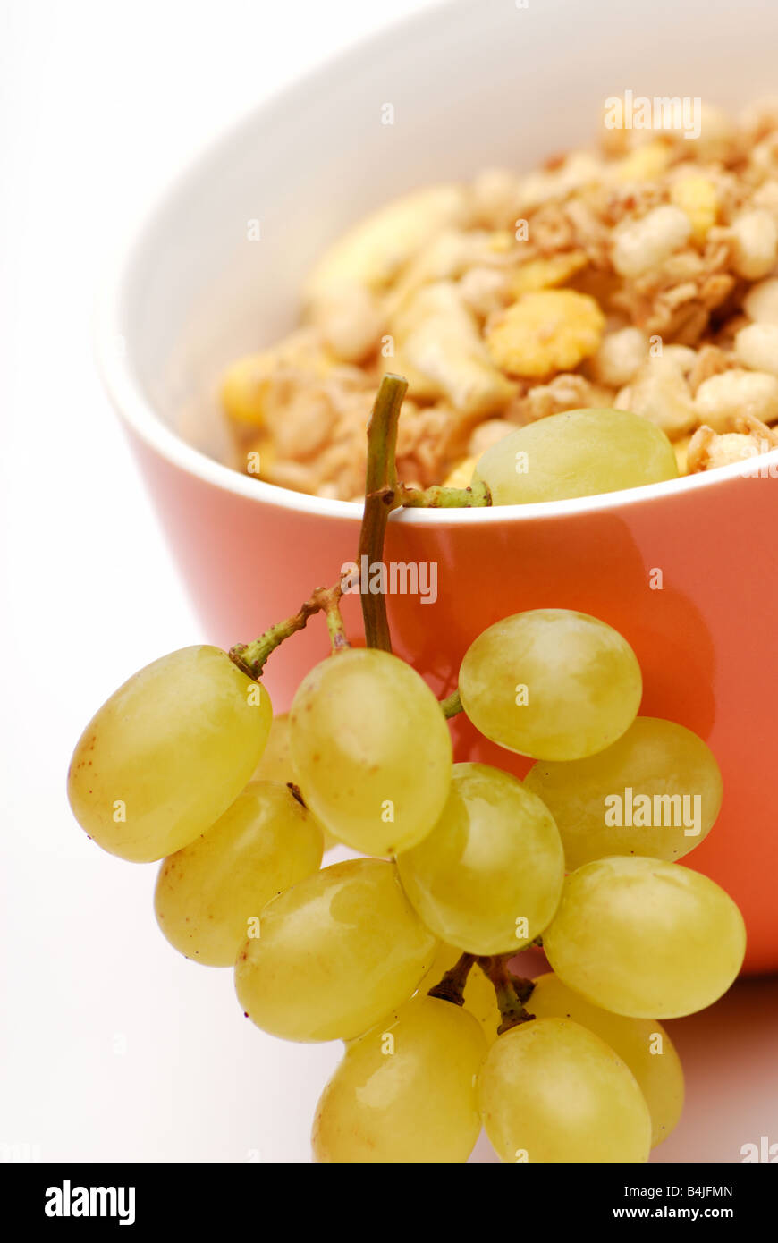 Healthy breakfast, bunch of grapes in a bowl of muesli. White ...