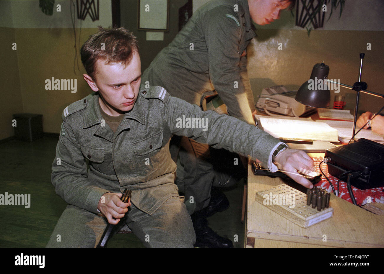 Polish border guard officer preparing a rifle for a night patrol ...