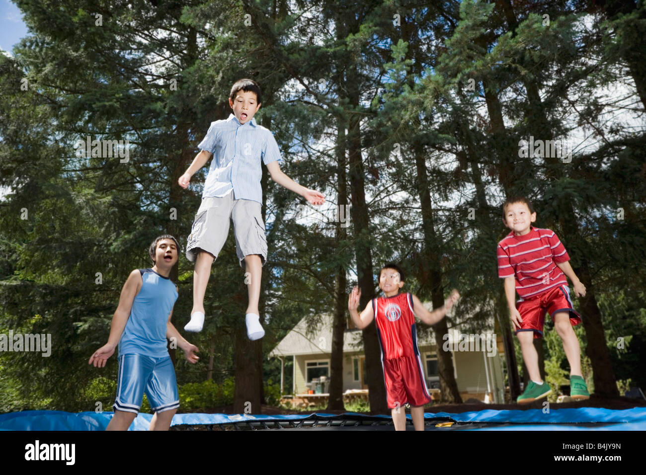 Asian brothers jumping on trampoline Stock Photo - Alamy