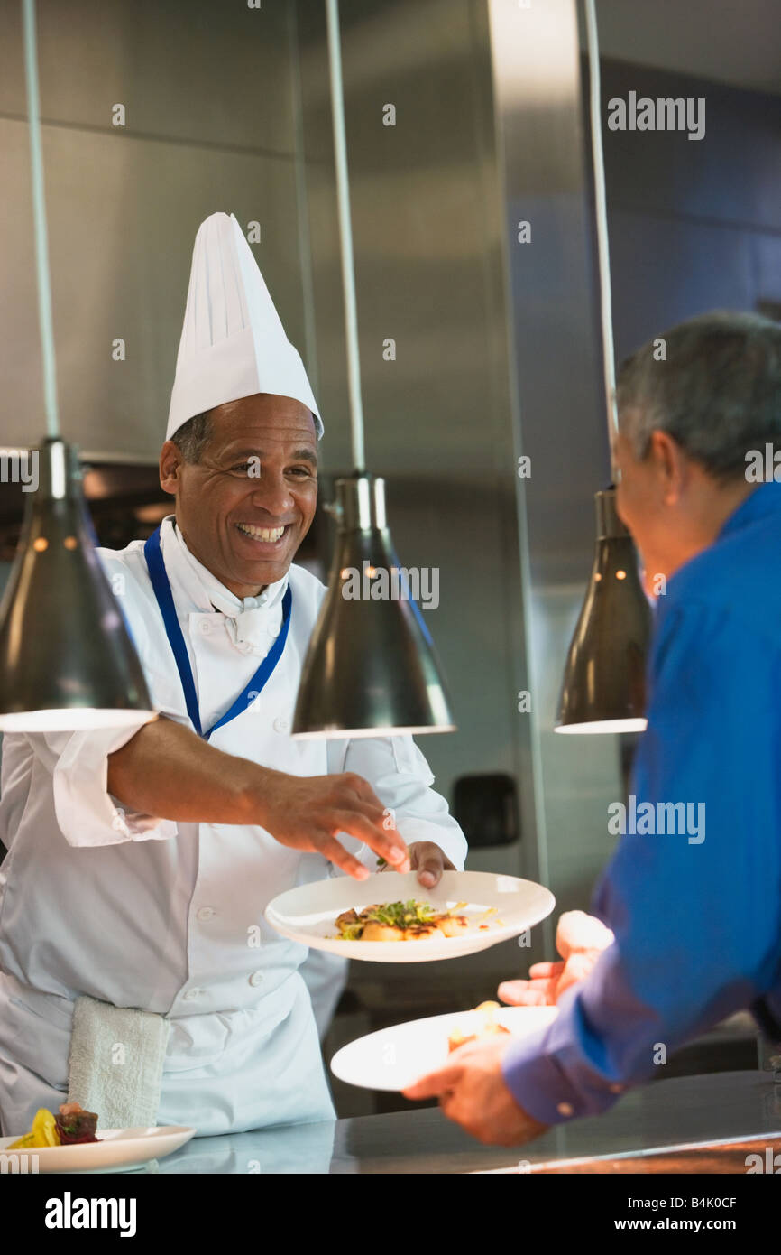 Mixed Race male chef garnishing plate of food Stock Photo - Alamy