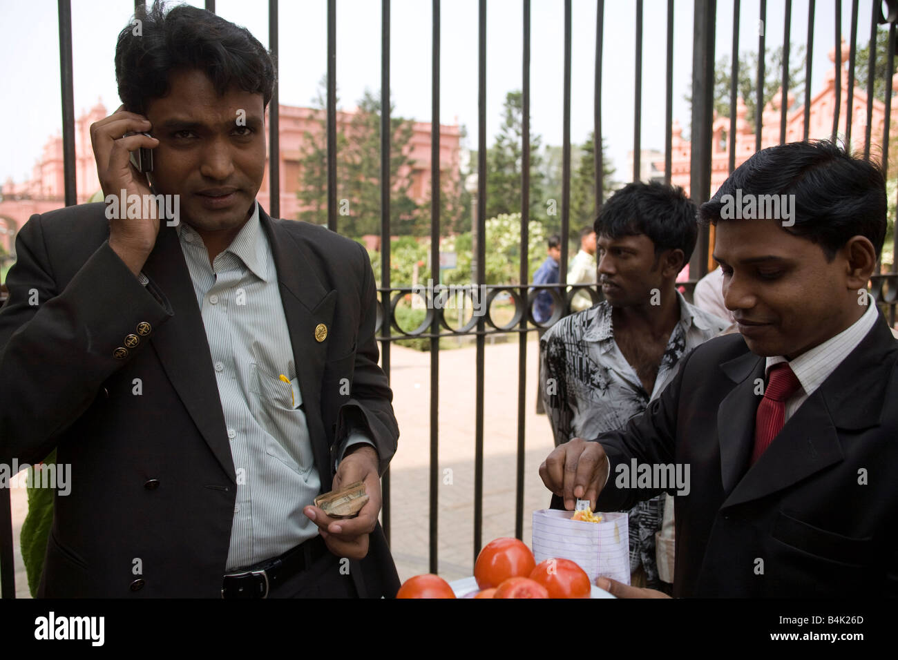 A man in a business suit talks on his cell phone in Dhaka Bangladesh ...