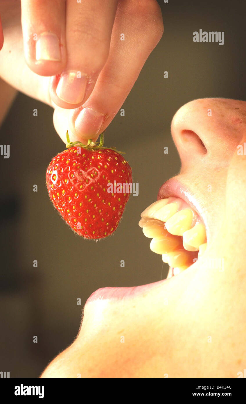 Food for the skin August 2002 model eating strawberry Stock Photo - Alamy