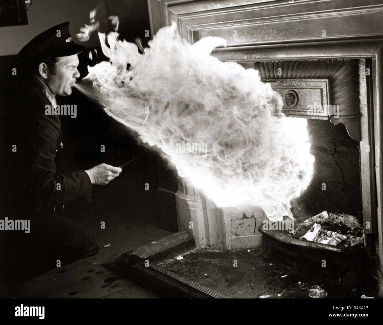 fire eater man blowing flames from mouth to light logs in fireplace ...