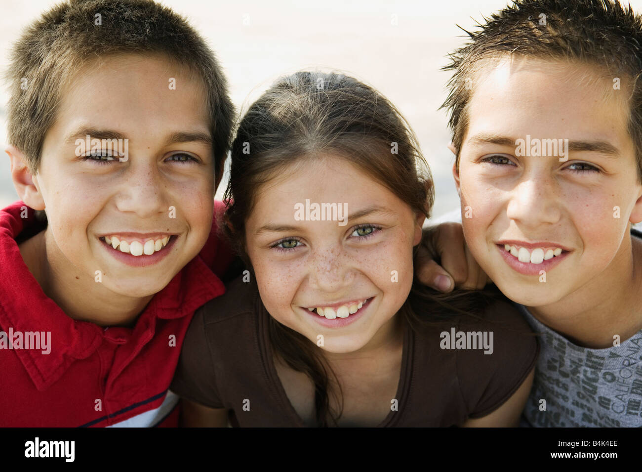 Hispanic twin brothers and sister hugging Stock Photo - Alamy