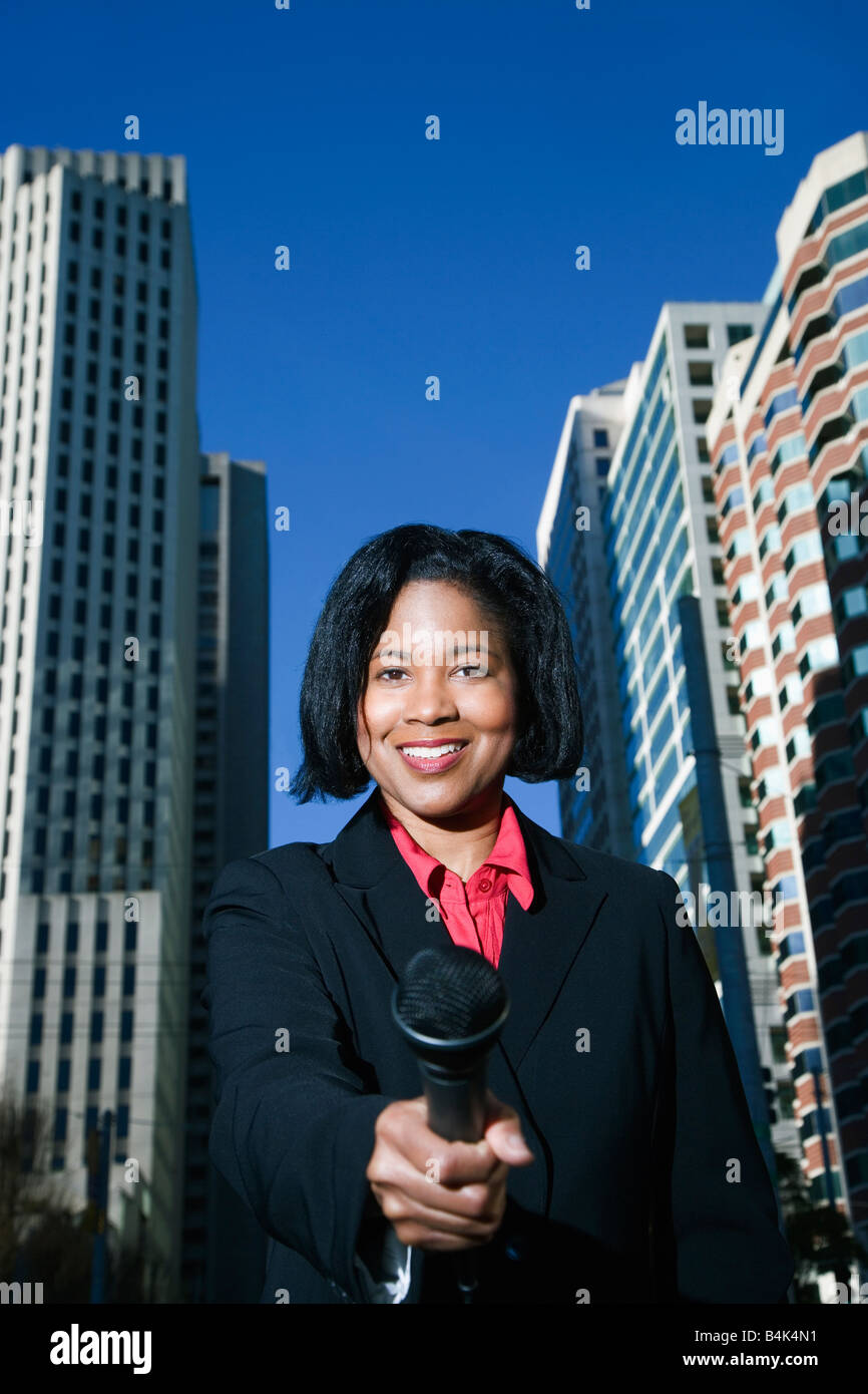 African female reporter holding microphone Stock Photo - Alamy
