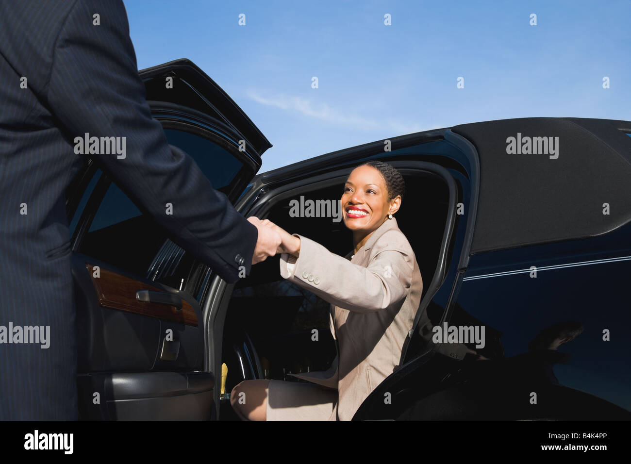 African businesswoman getting out of limousine Stock Photo - Alamy