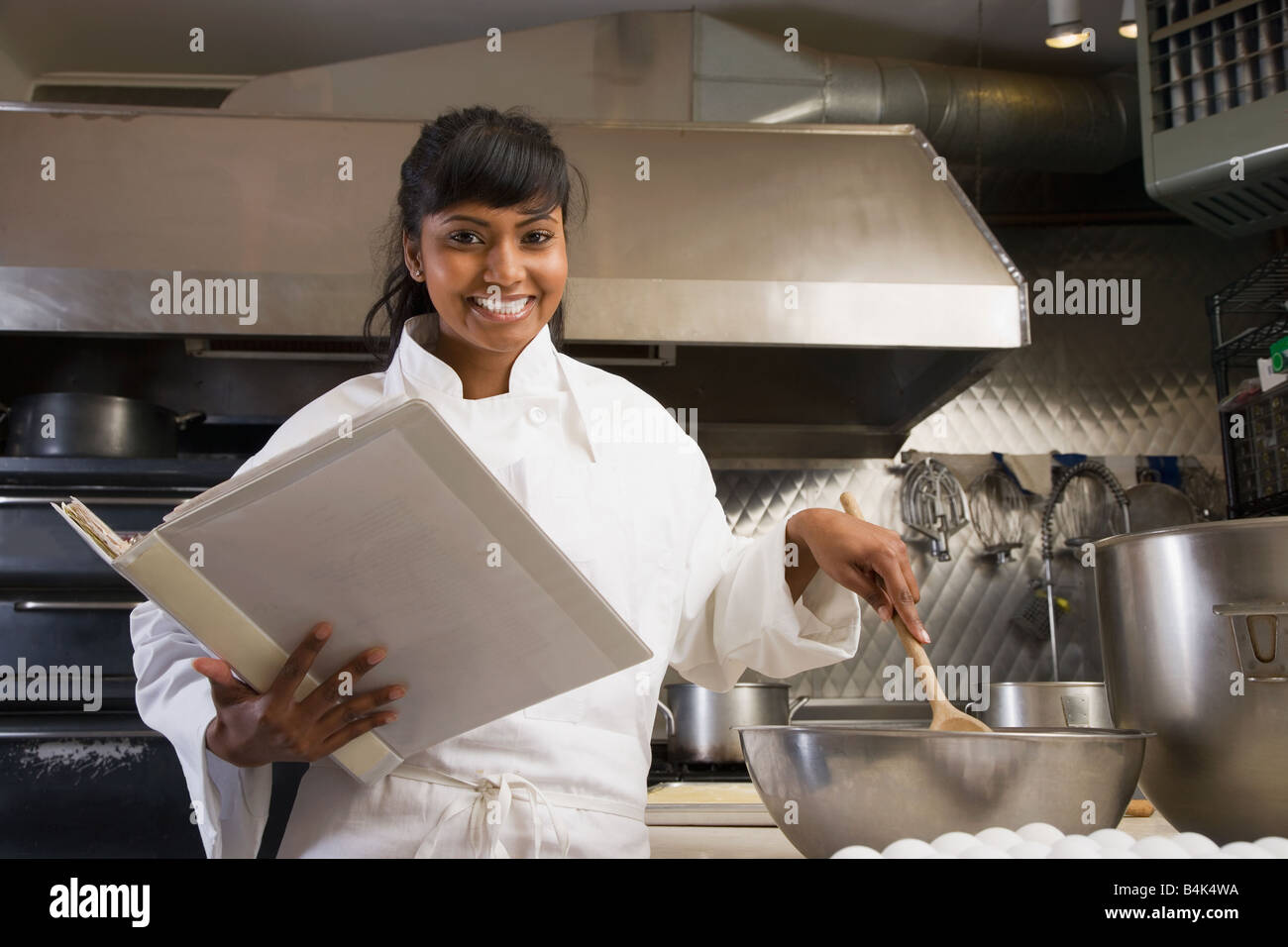 Mixed Race female baker mixing batter Stock Photo - Alamy