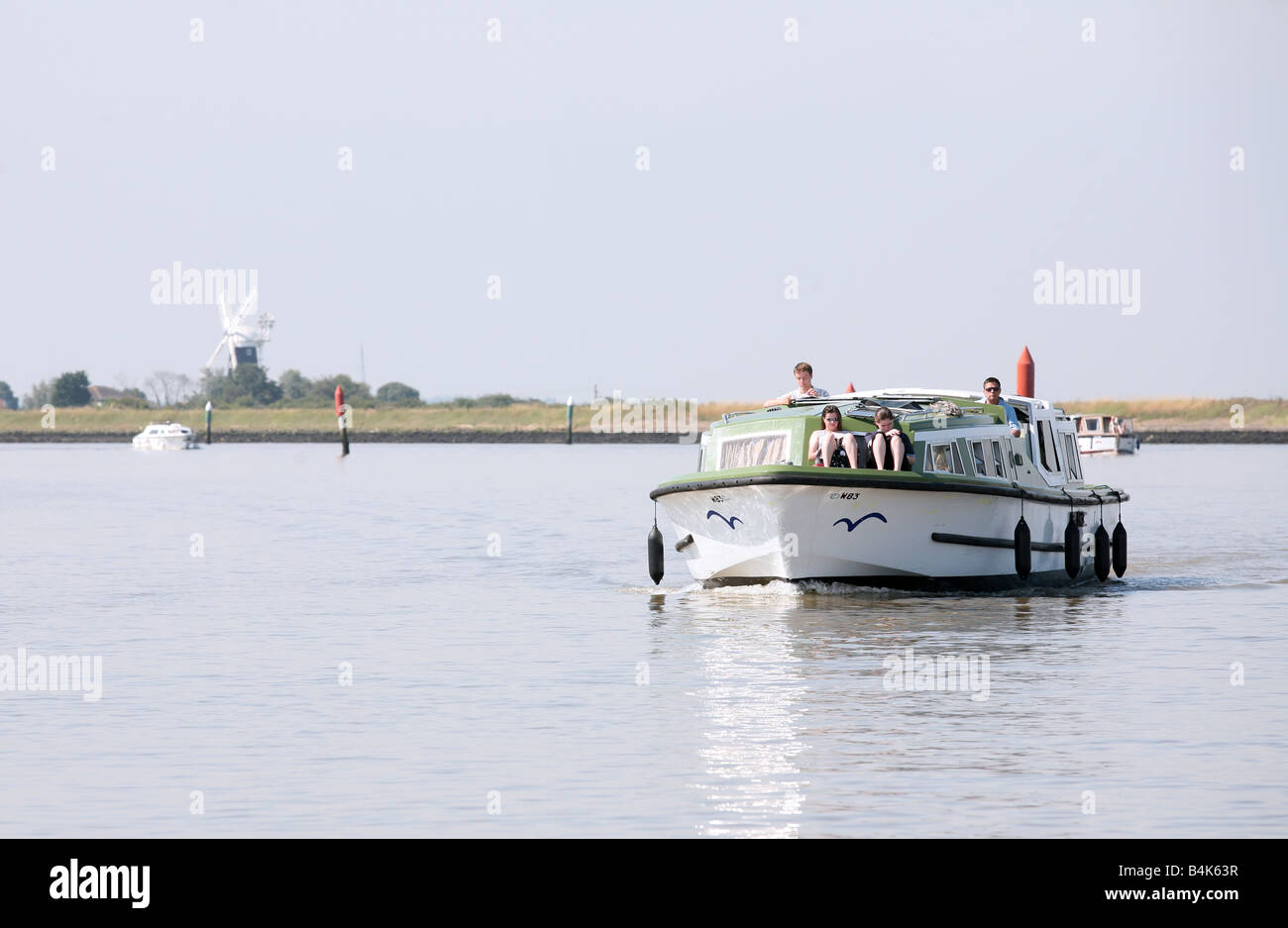 A family cruising the Norfolk Broads near Great Yarmouth Berney Mill is ...
