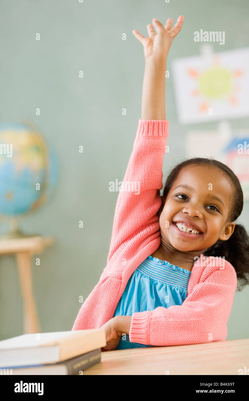 Mixed race girl raising hand to answer question Stock Photo - Alamy