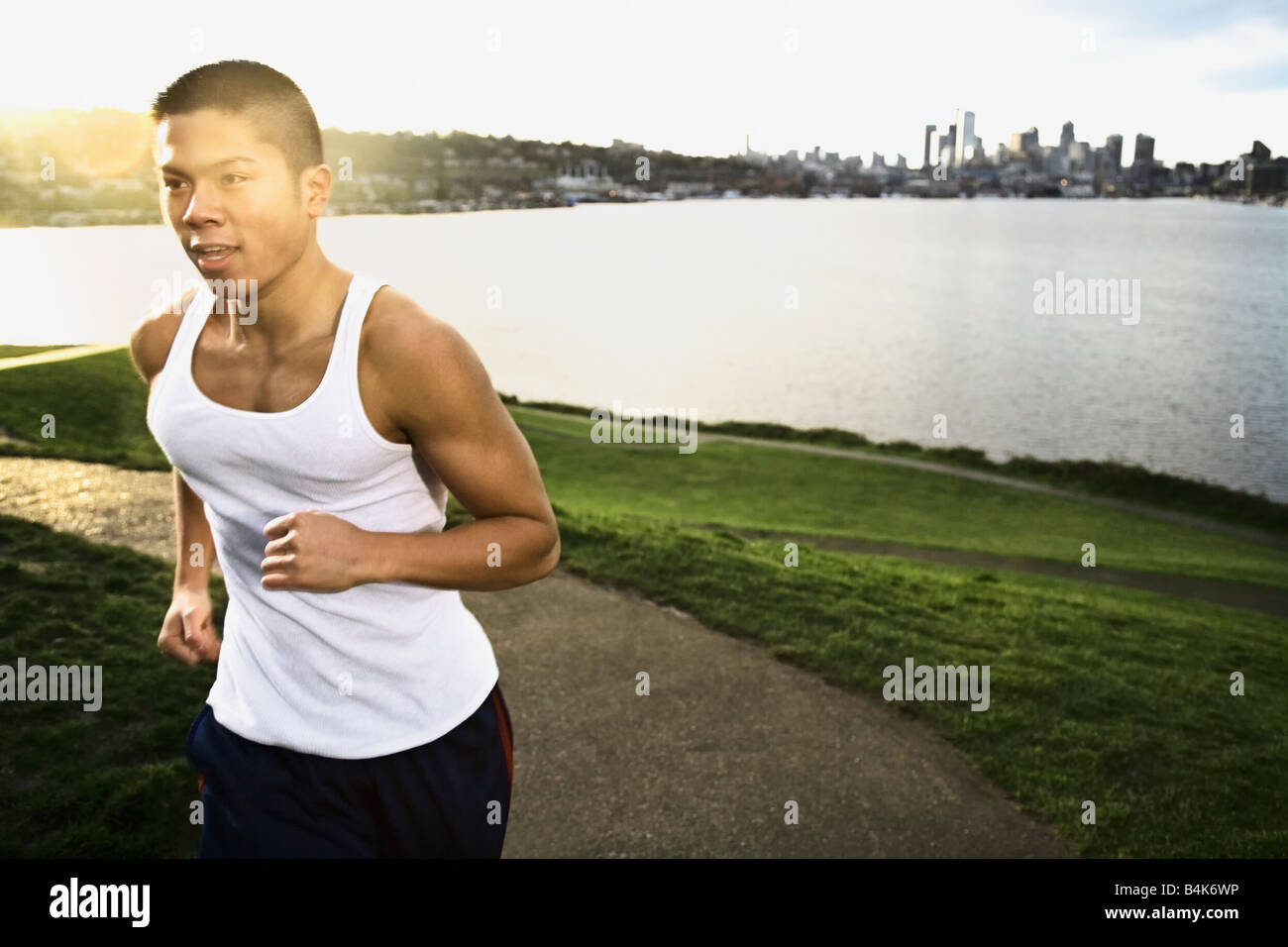Asian man jogging along urban waterfront Stock Photo - Alamy