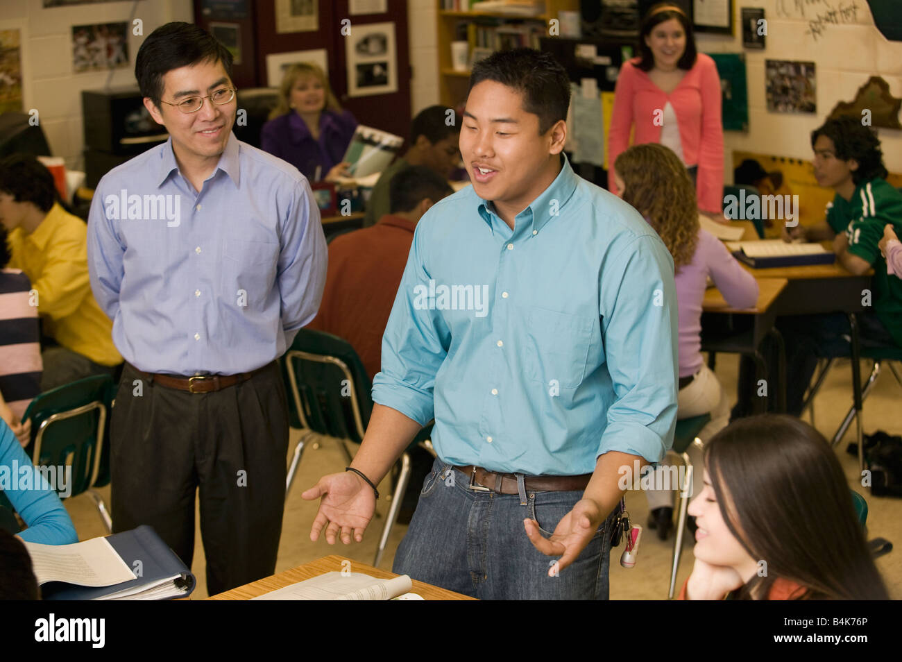 Asian teacher talking to students in classroom Stock Photo - Alamy
