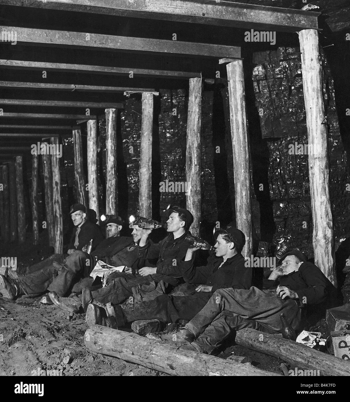 Miners down a mine shaft sitting eating drinking and Smoking in the ...