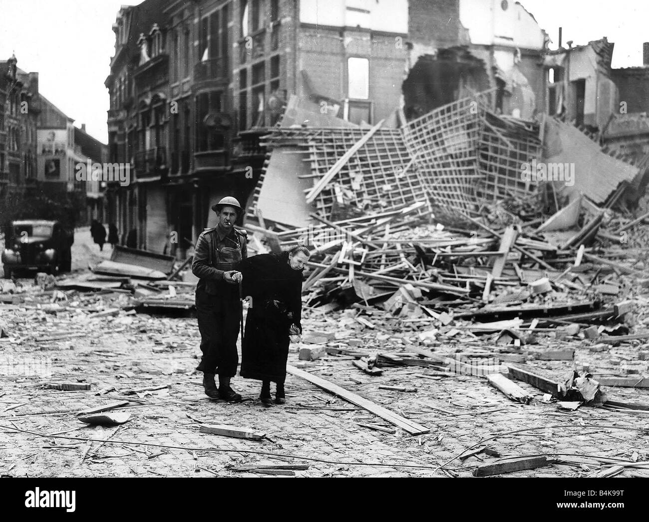 WW2 Invasion of France 1944 A soldier helps an elderly woman through ...