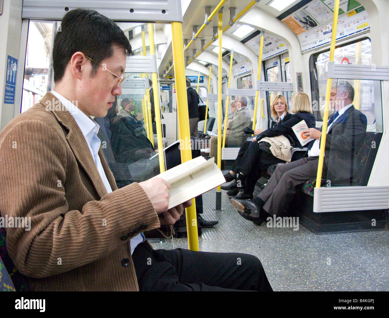 Passenger reading a book on the London Underground Stock Photo - Alamy
