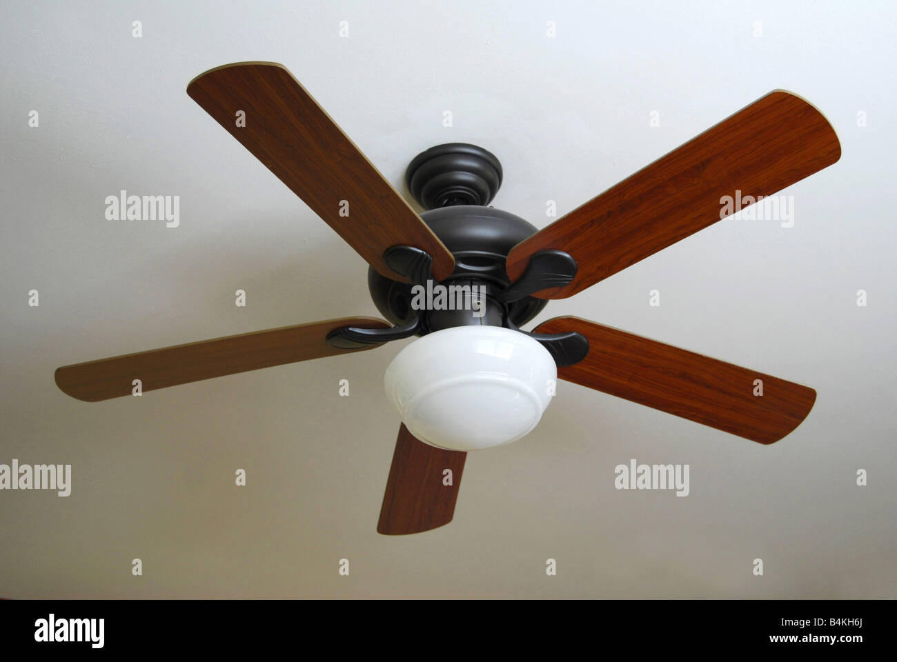 A modern ceiling fan installed on a textured white ceiling Stock Photo ...