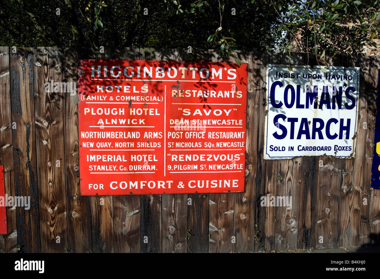 Old metal advertising signs on a wooden fence Stock Photo - Alamy