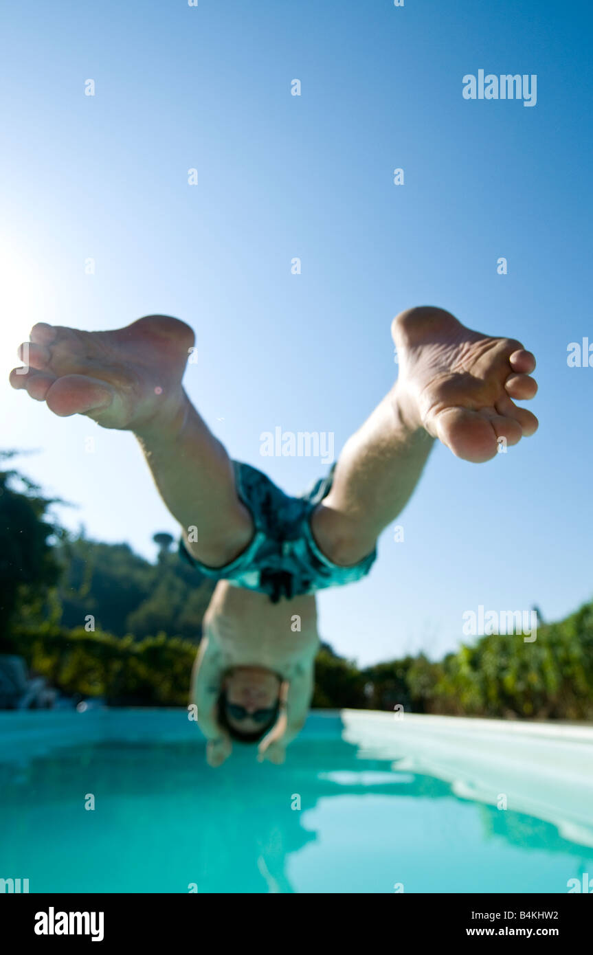 Young man diving into a swimming pool as seen from behind Stock Photo ...