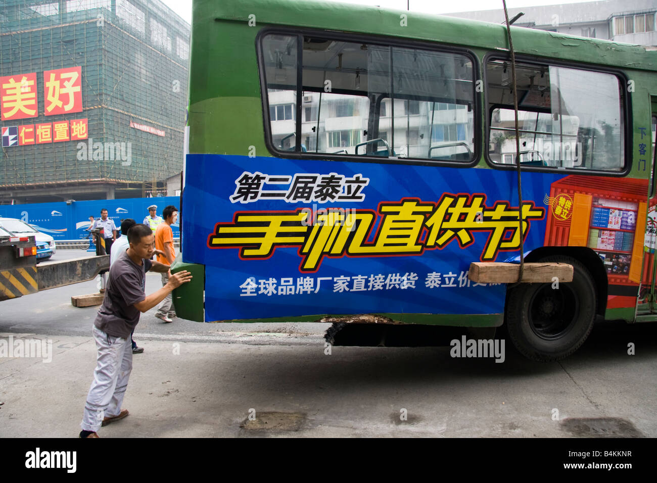 A bus in Chengdu China gets its back axle stuck in a huge hole Stock ...