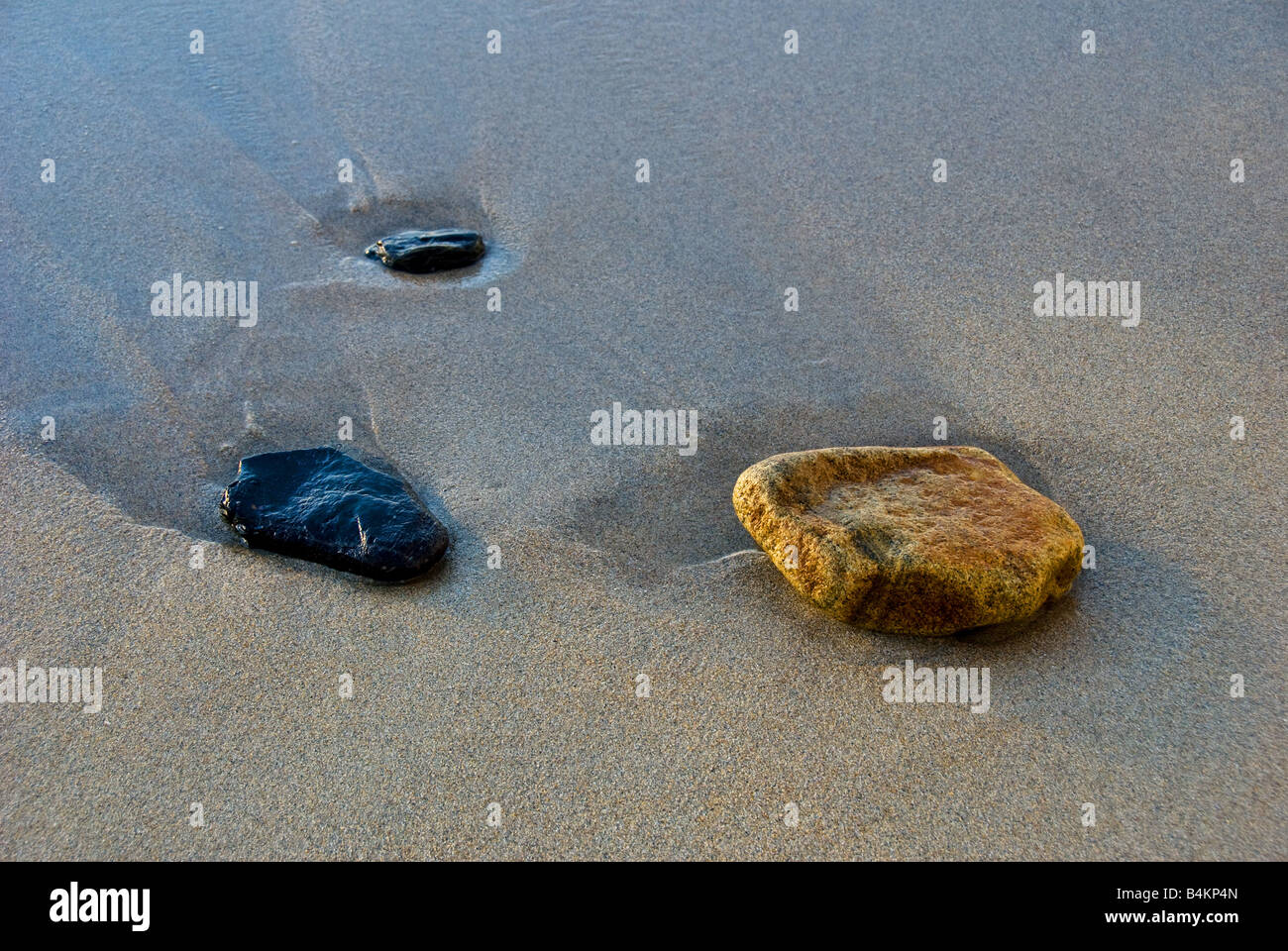 Three stones in the sand on the beach at Sennen in Cornwall Stock Photo ...