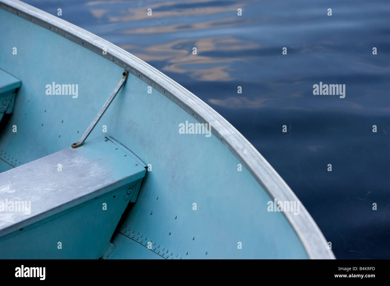An old pale blue metal outboard motorboat on a lake at dawn Stock Photo ...