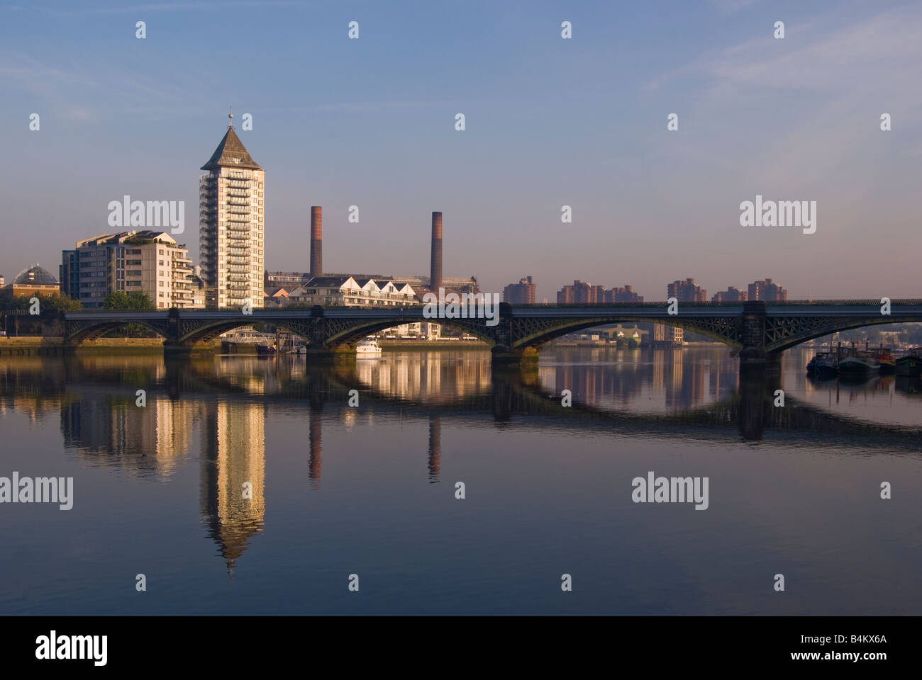 Chelsea railway bridge and reflection of apartments in river thames ...