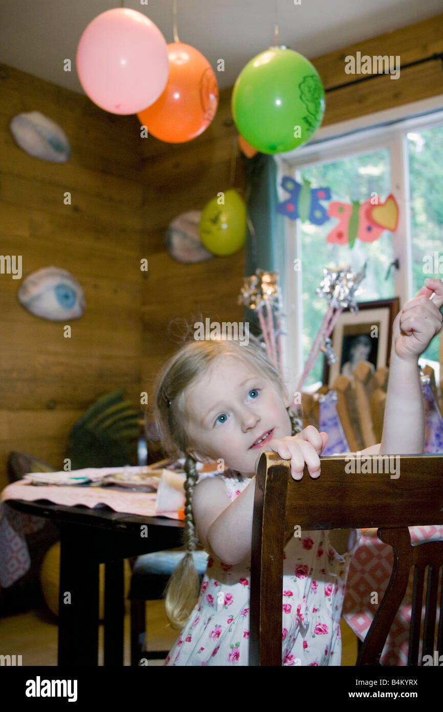 young girl at birthday party. sitting down waiting for guests in ...
