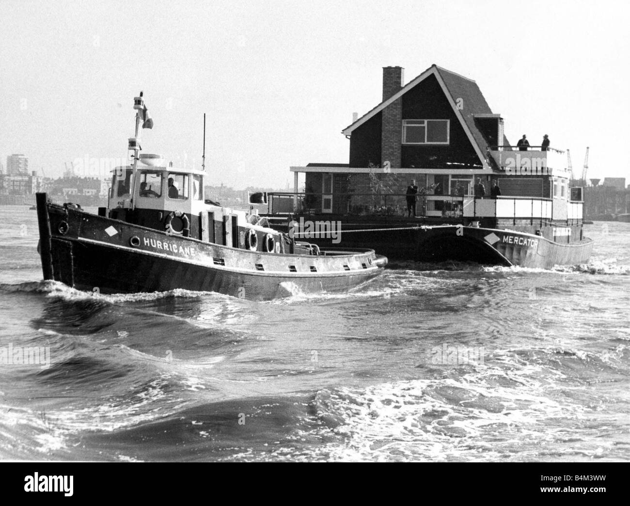 A tug boat hauling a floating home along to its new site on the River ...