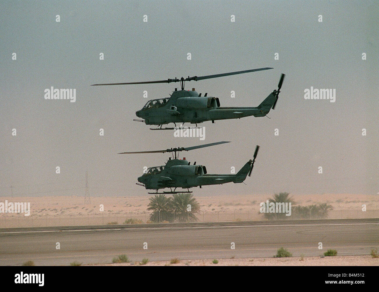 Two US Army Cobra gunships Oct 1990 hover over airfield during the Gulf ...