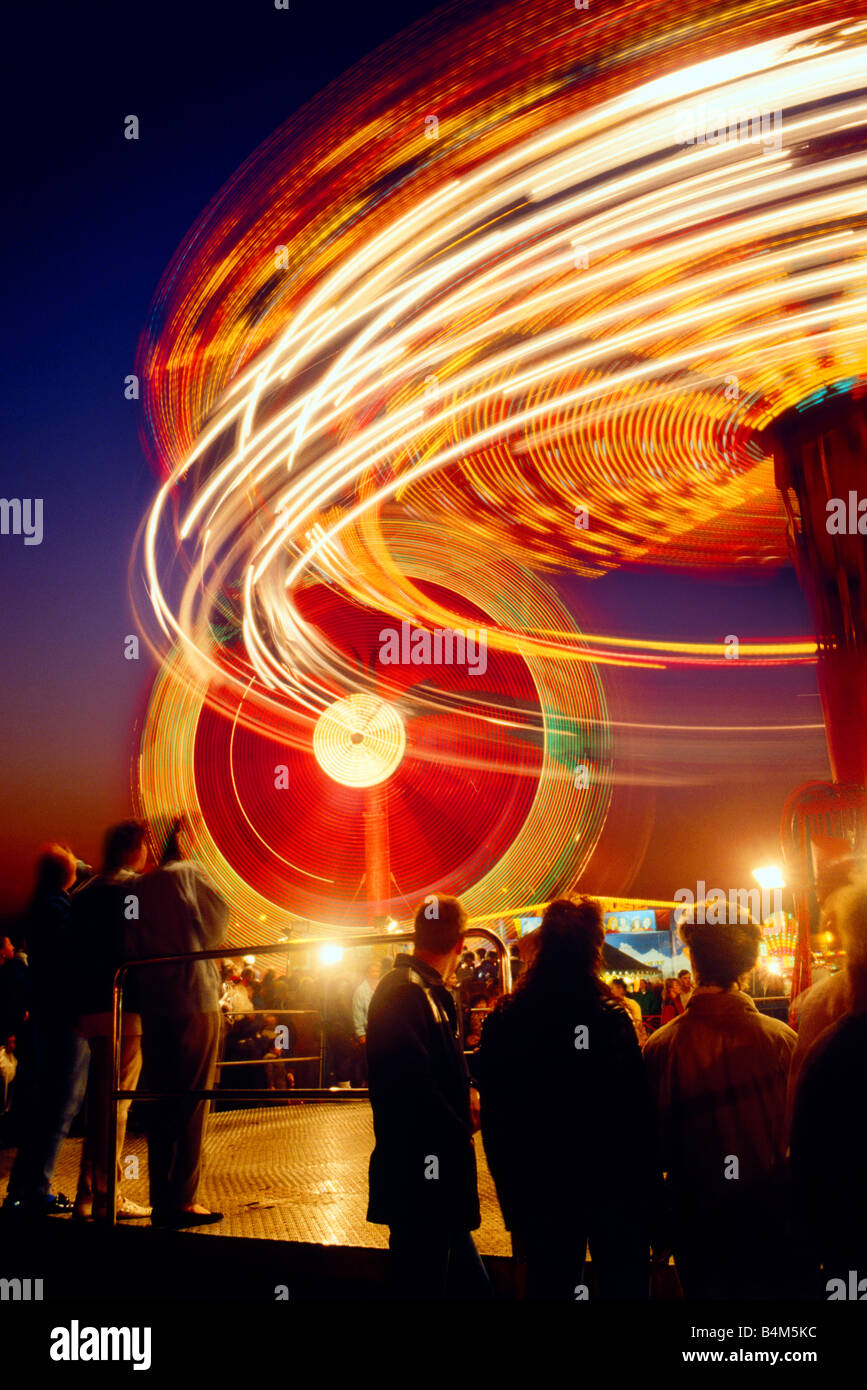 Spinning fairground ride at night England UK Stock Photo - Alamy