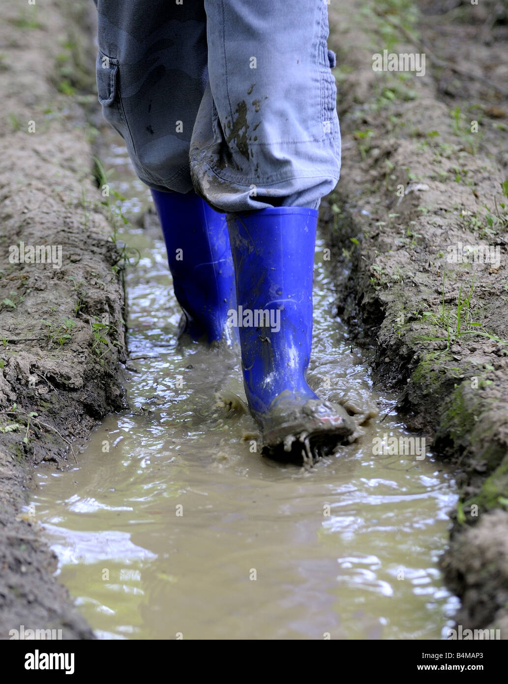 Boy in wellington boots in a muddy rut Stock Photo - Alamy