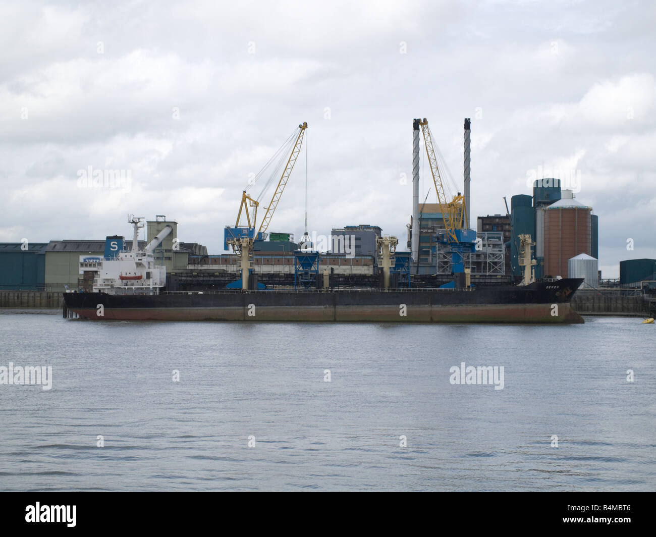 ship docked and unloading cargo Stock Photo - Alamy