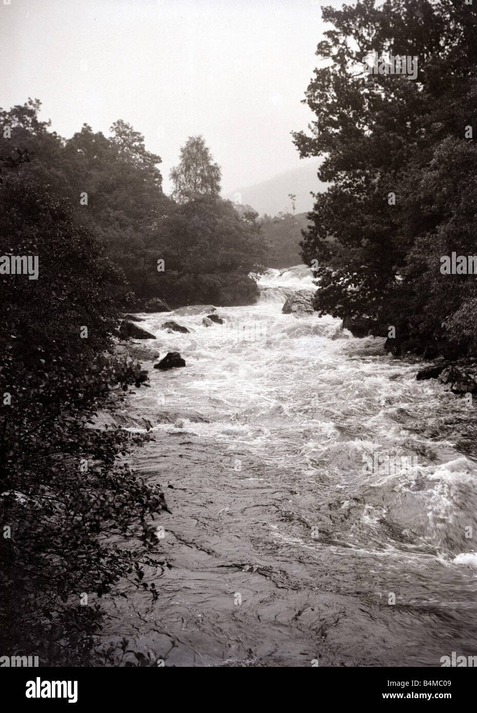 A highland river in full flow after the snow has melted from the high ...