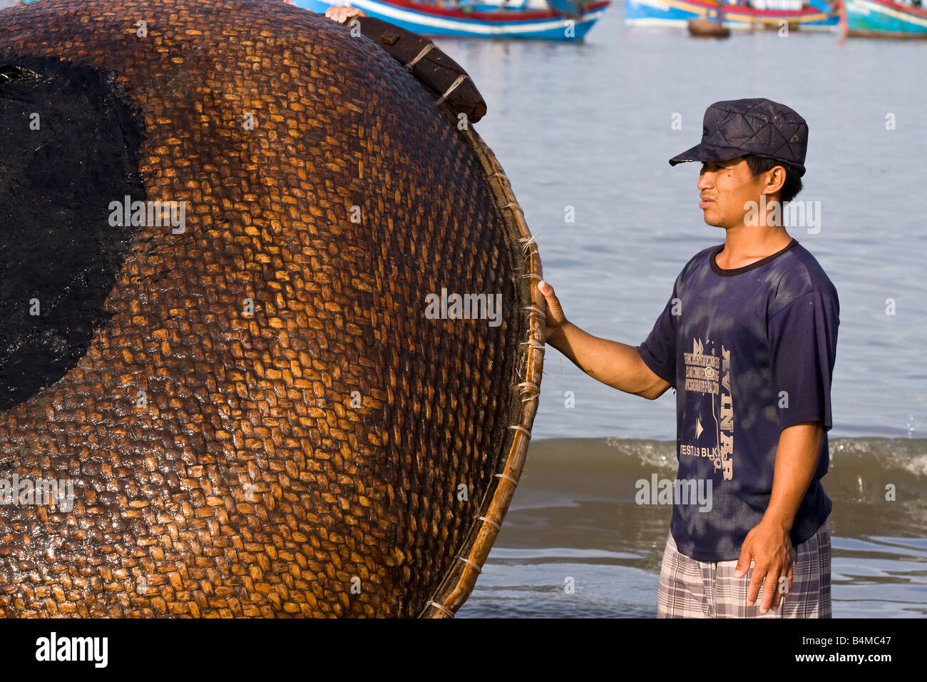 Fisherman cleaning his round bamboo fishing boat Stock Photo - Alamy
