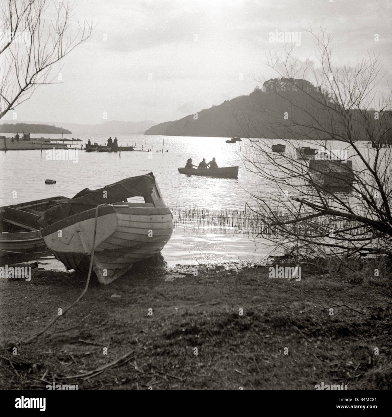 Rowing boats on scenic lake Row boat moored ashore by lakeside Wooded ...
