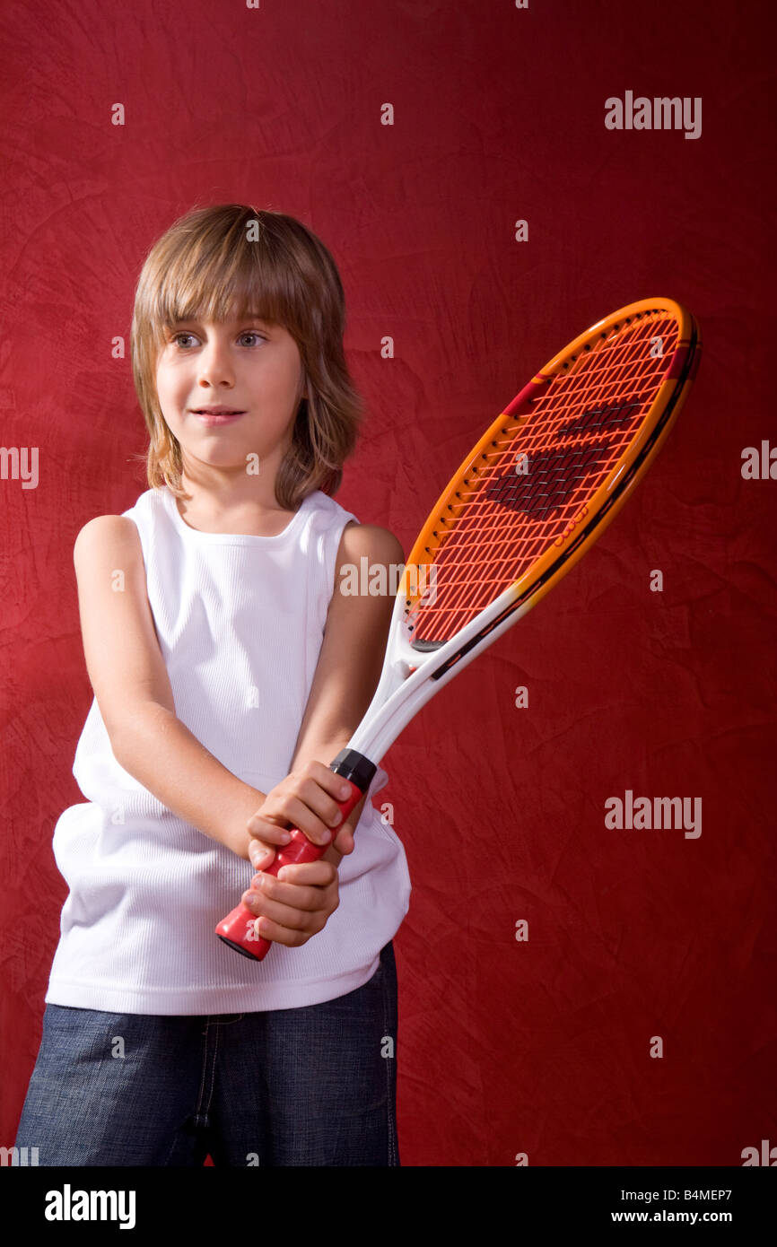 Funny little boy holding a new tennis racket Stock Photo - Alamy