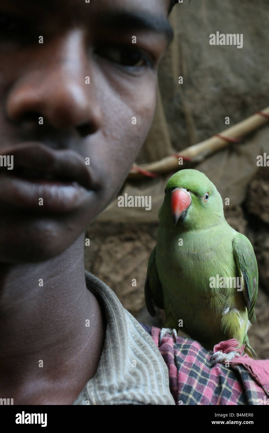A village boy with his pet parrot. Photograph taken at a remote village ...