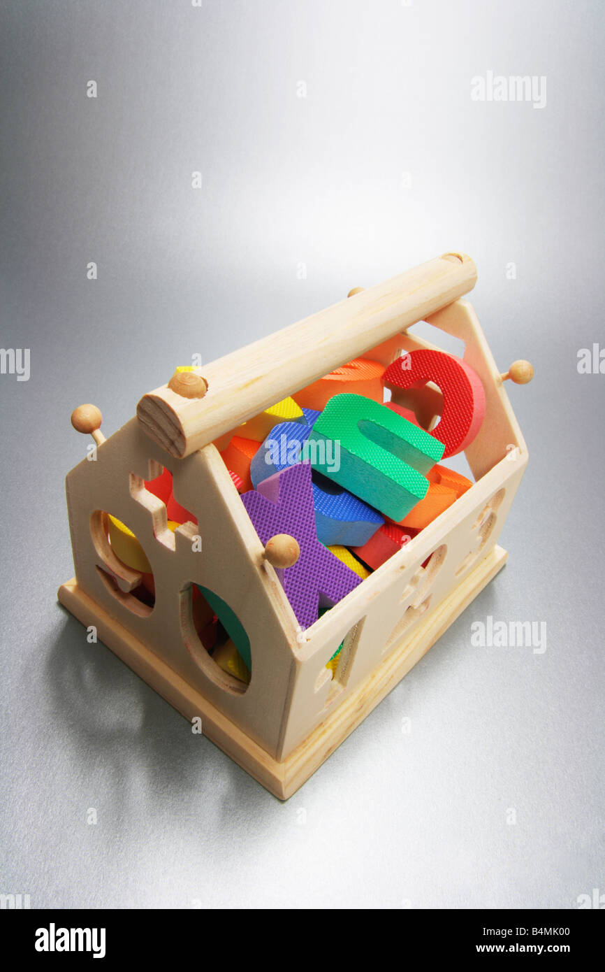 Plastic Alphabets in Wooden House Shaped Toy Box Stock Photo - Alamy