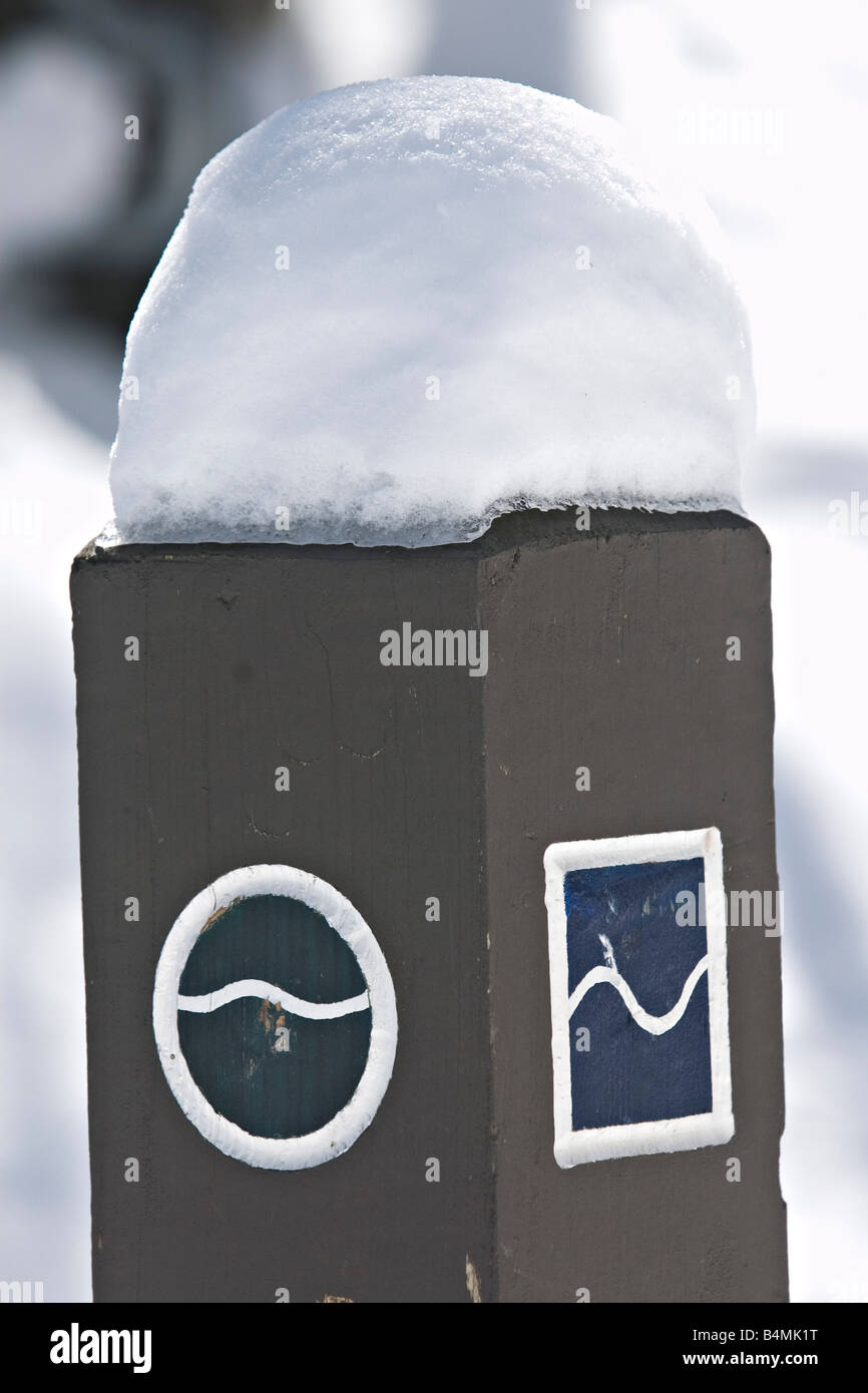 A hiking trail signpost displays the symbols for an easy trail and a ...
