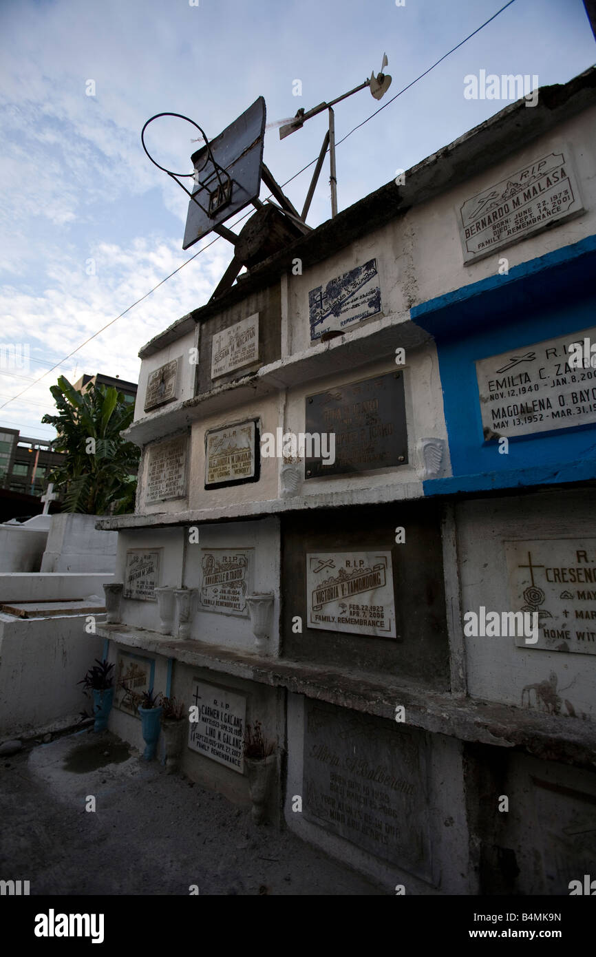 A basketball hoops affixed atop a stack of tombs at the Makati Catholic ...