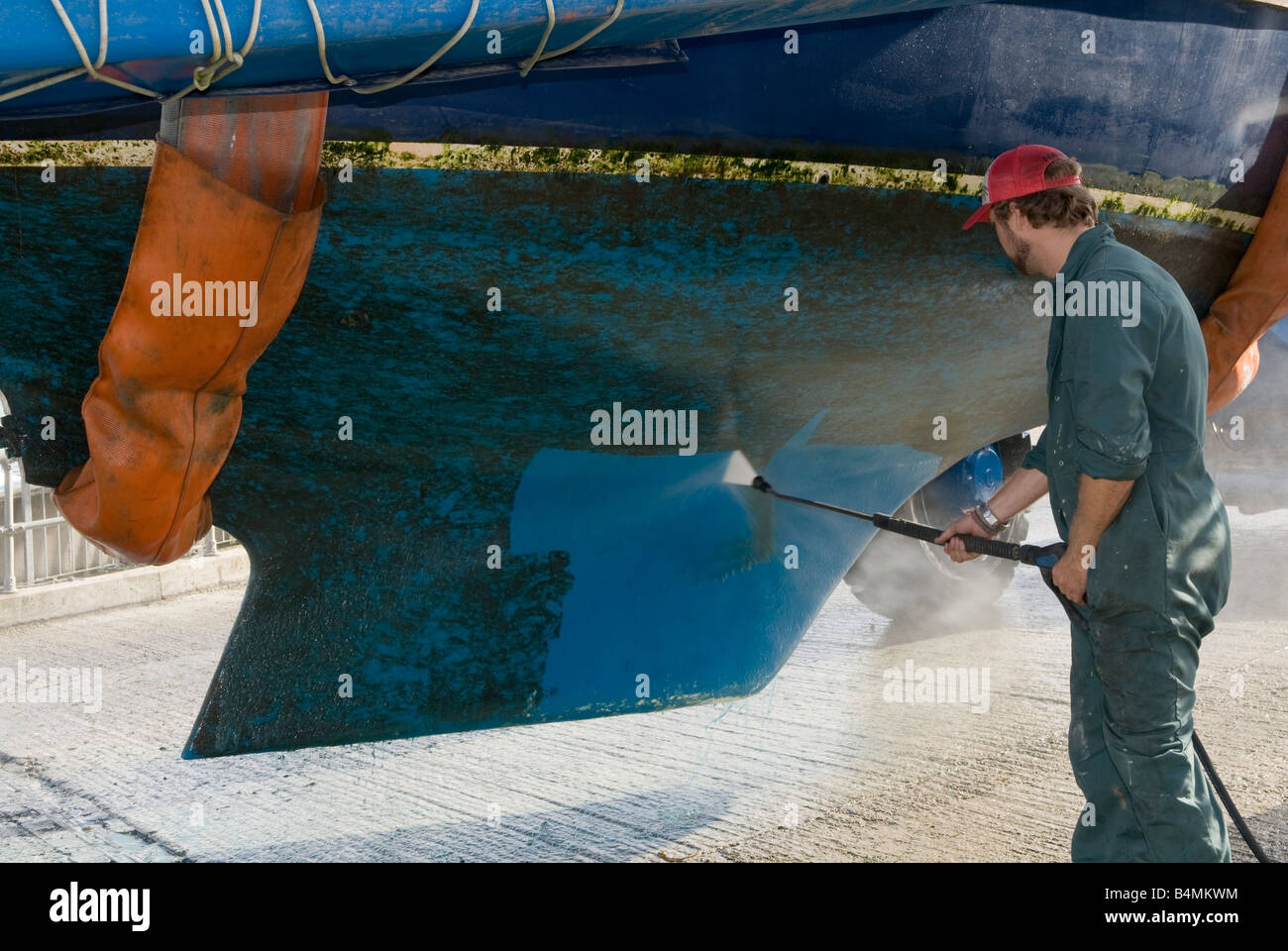 Worker Jet Washing the Keel of a Sailing Yacht Stock Photo - Alamy