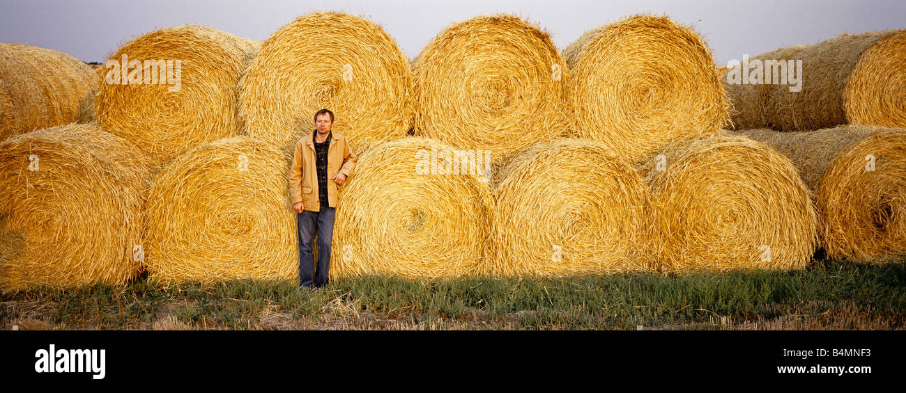 A person standing in front of Hay Bales Stock Photo - Alamy