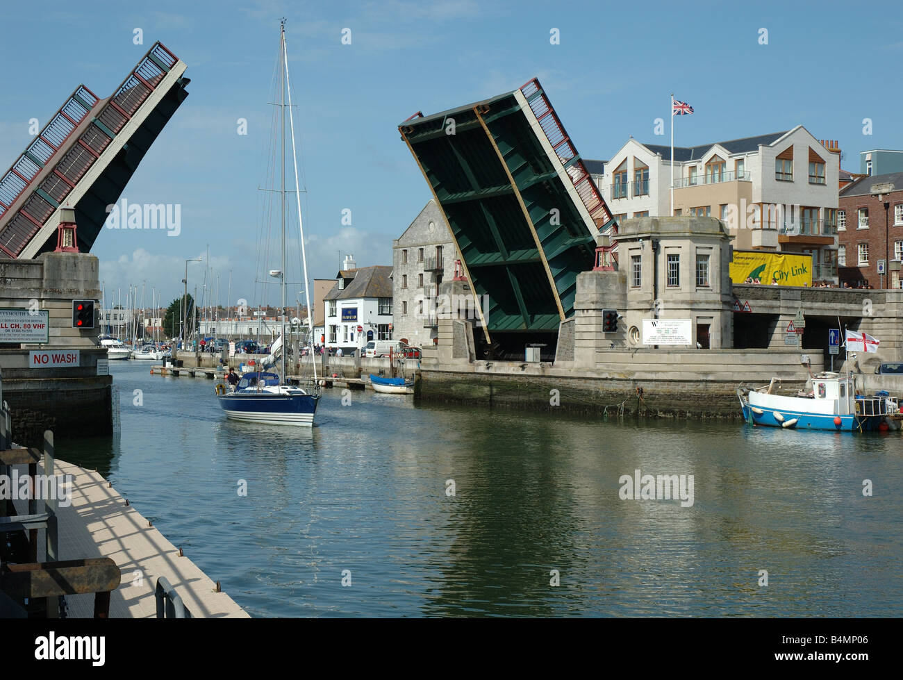 yacht passing through the raised Town Bridge, Weymouth, Dorset, England ...