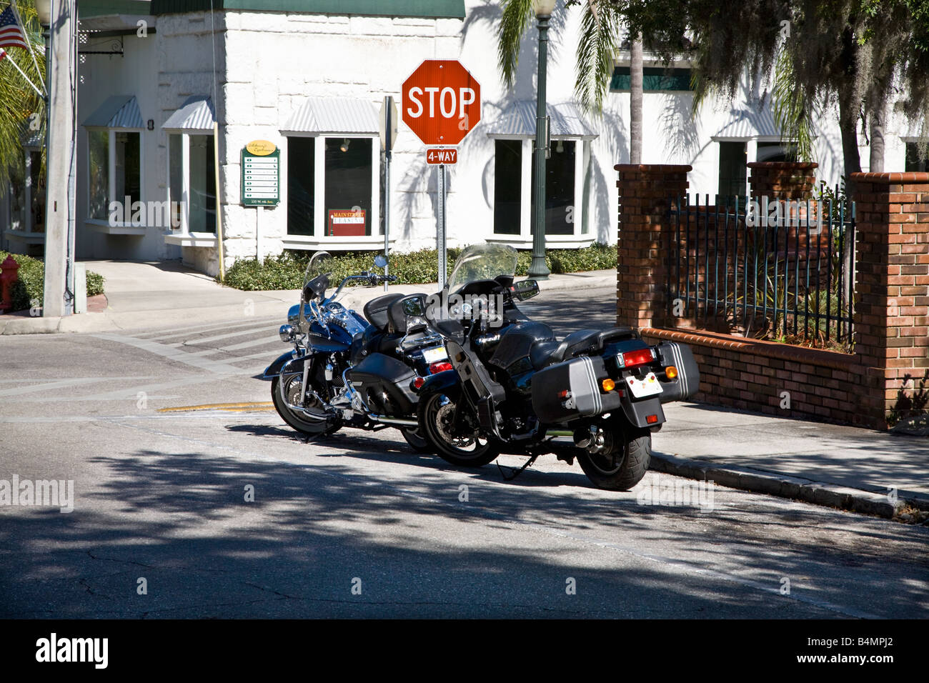 Two motorcycles parked by a stop sign in small town America Stock Photo ...