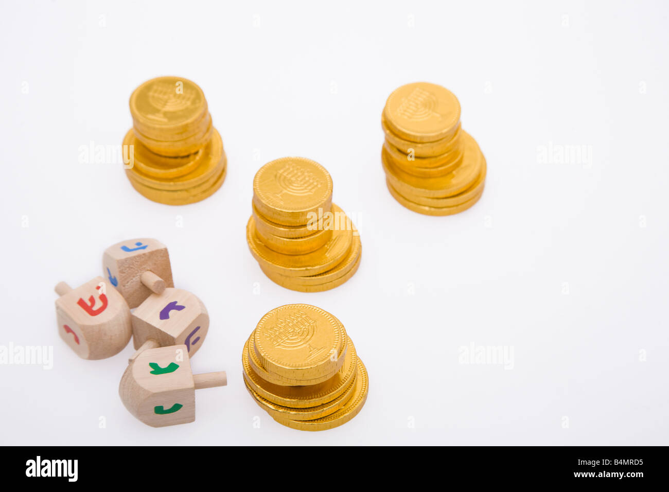 Four stacks of gelt (chocolate coins) and four dreidels ready for the ...