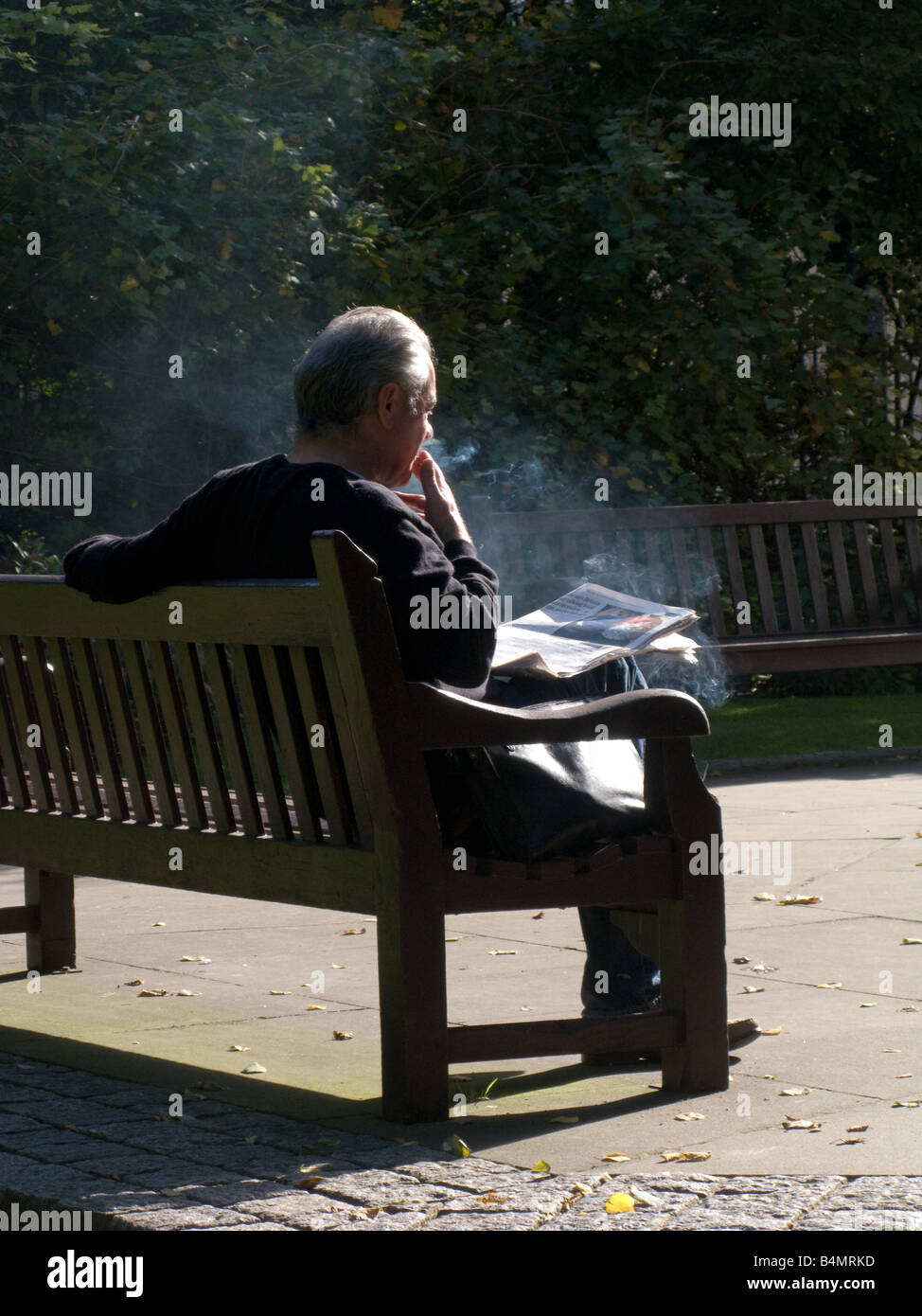 A man smoking a cigarette in the open air Stock Photo - Alamy