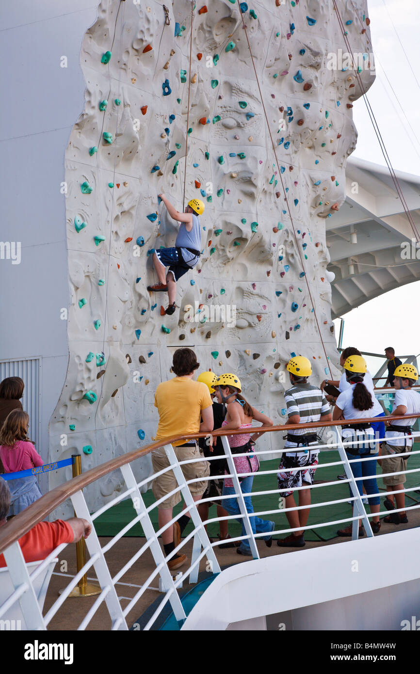 Teenage boy climbing artificial rock wall onboard Royal Caribbean ...