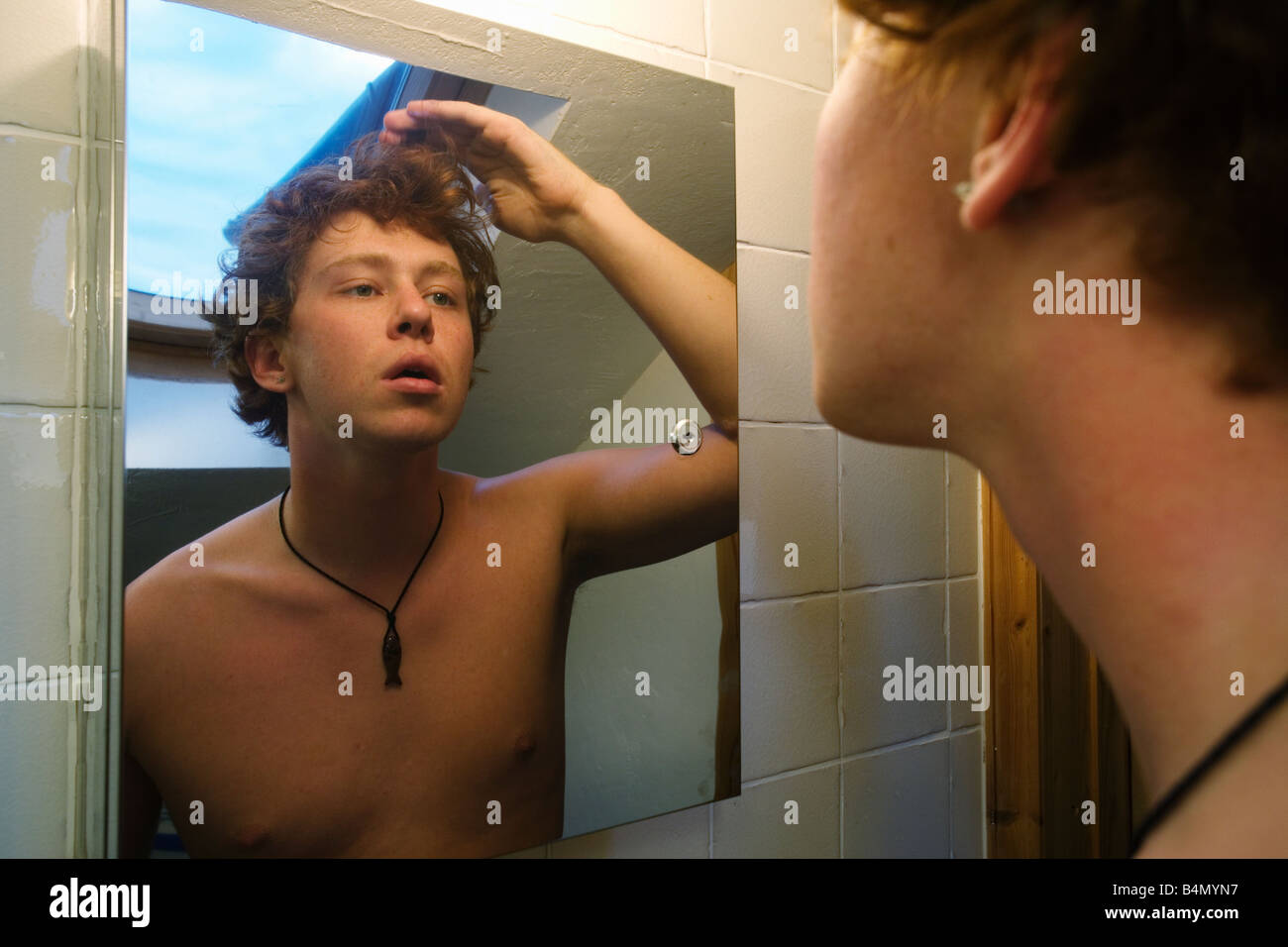 Teenage boy fixing his hair in the bathroom mirror Stock Photo - Alamy