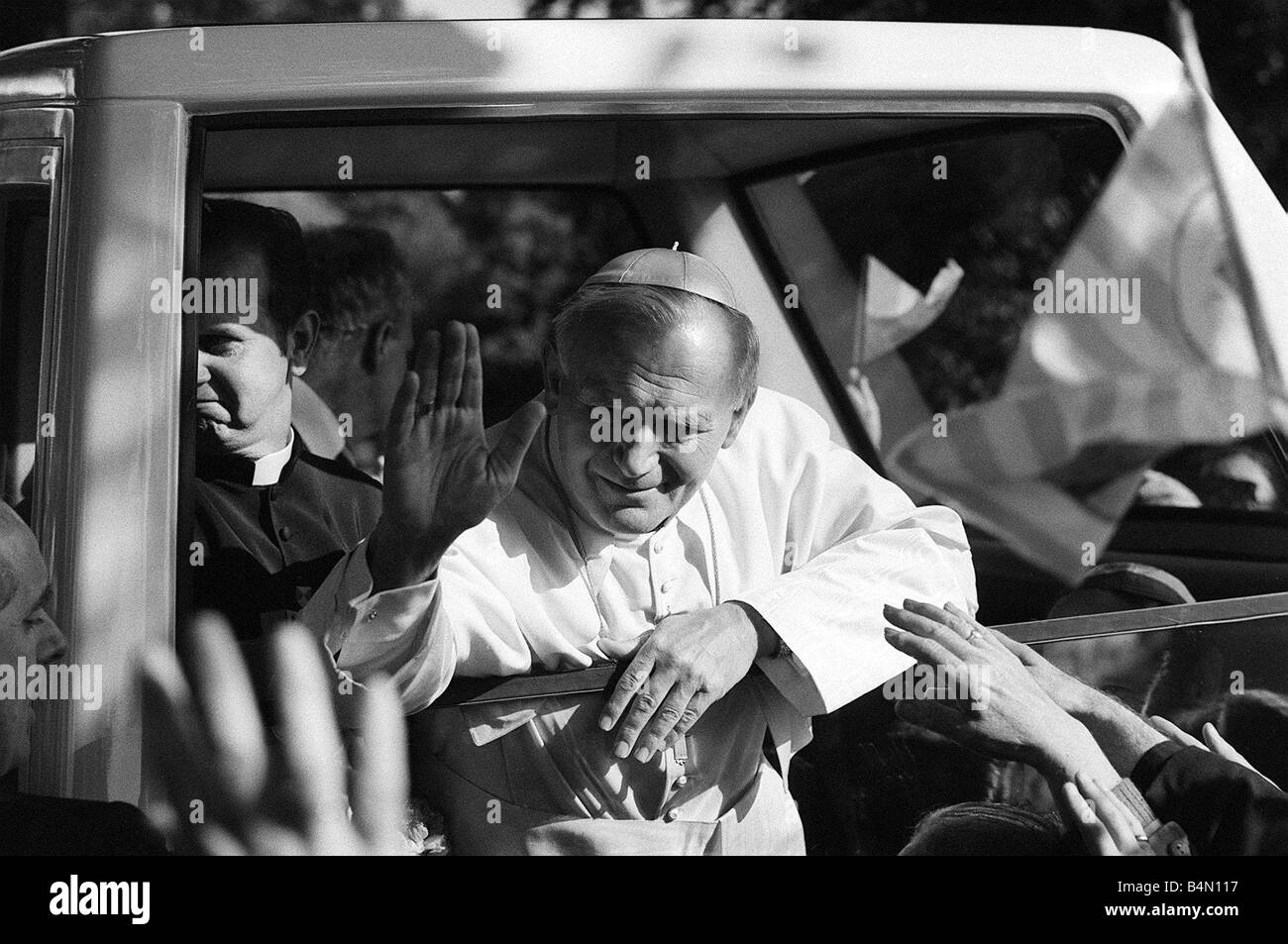 Pope John Paul II waves to the congregation from his pope mobile ...