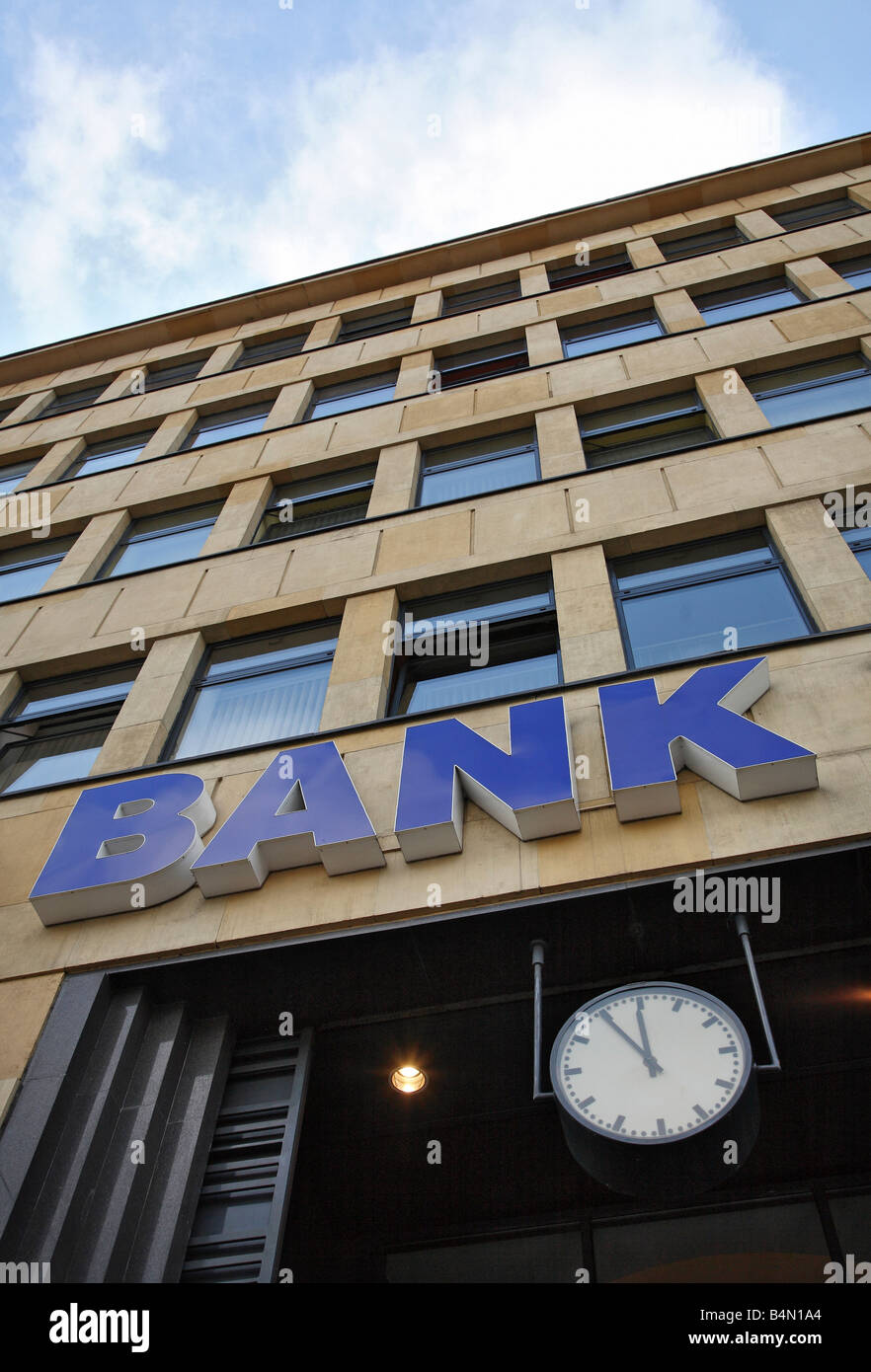 BANK sign on a building and a clock showing five to twelve Stock Photo ...
